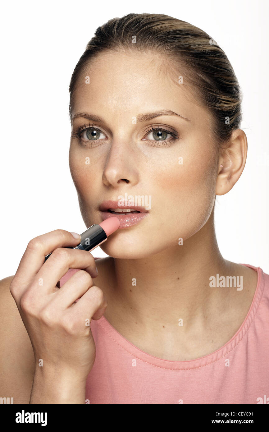 Woman applying pink lipstick hi-res stock photography and images - Alamy
