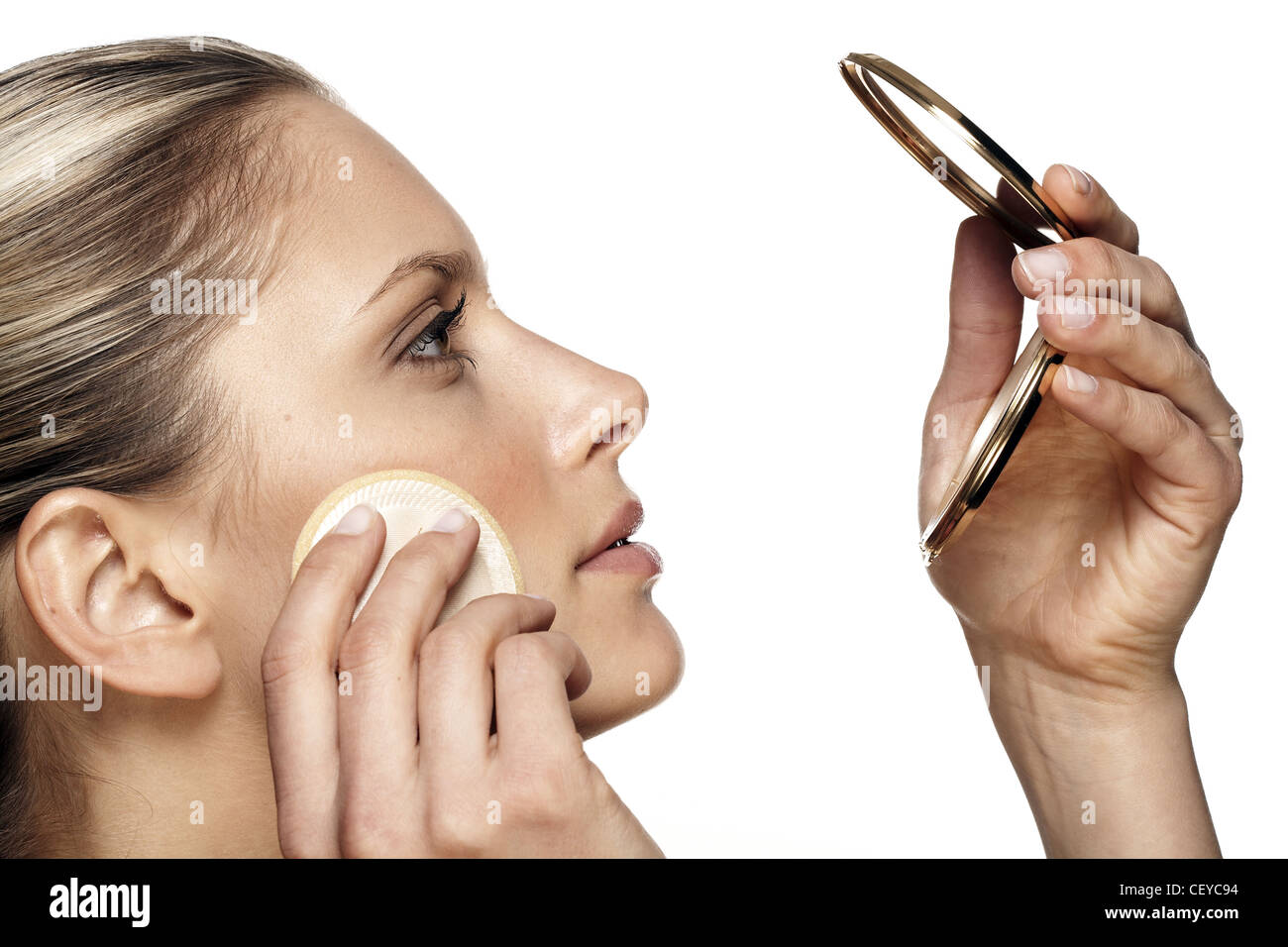 Female applying powder to face holding compact Stock Photo - Alamy