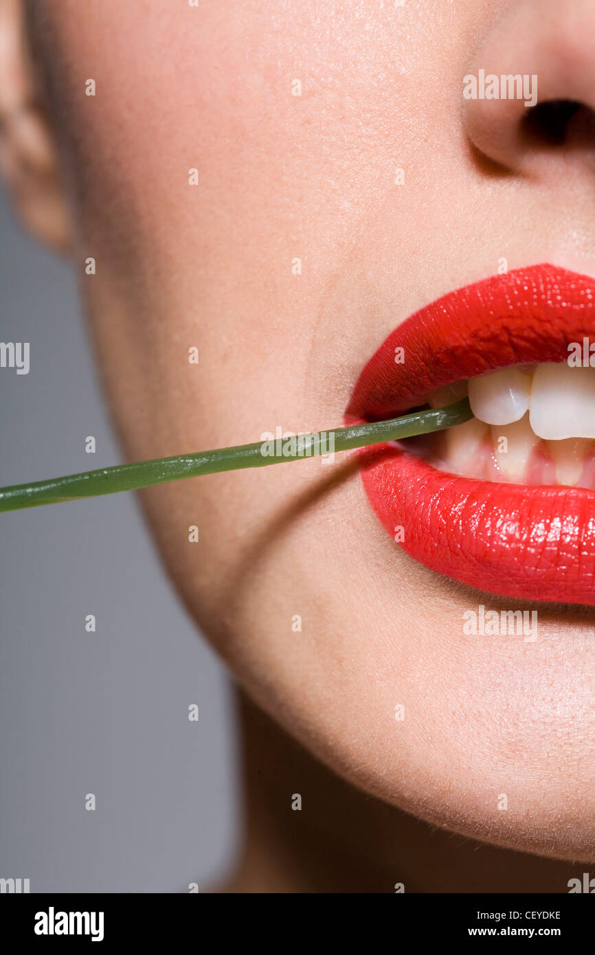 Female wearing bright red lipstick biting a apple lace sweet Stock ...