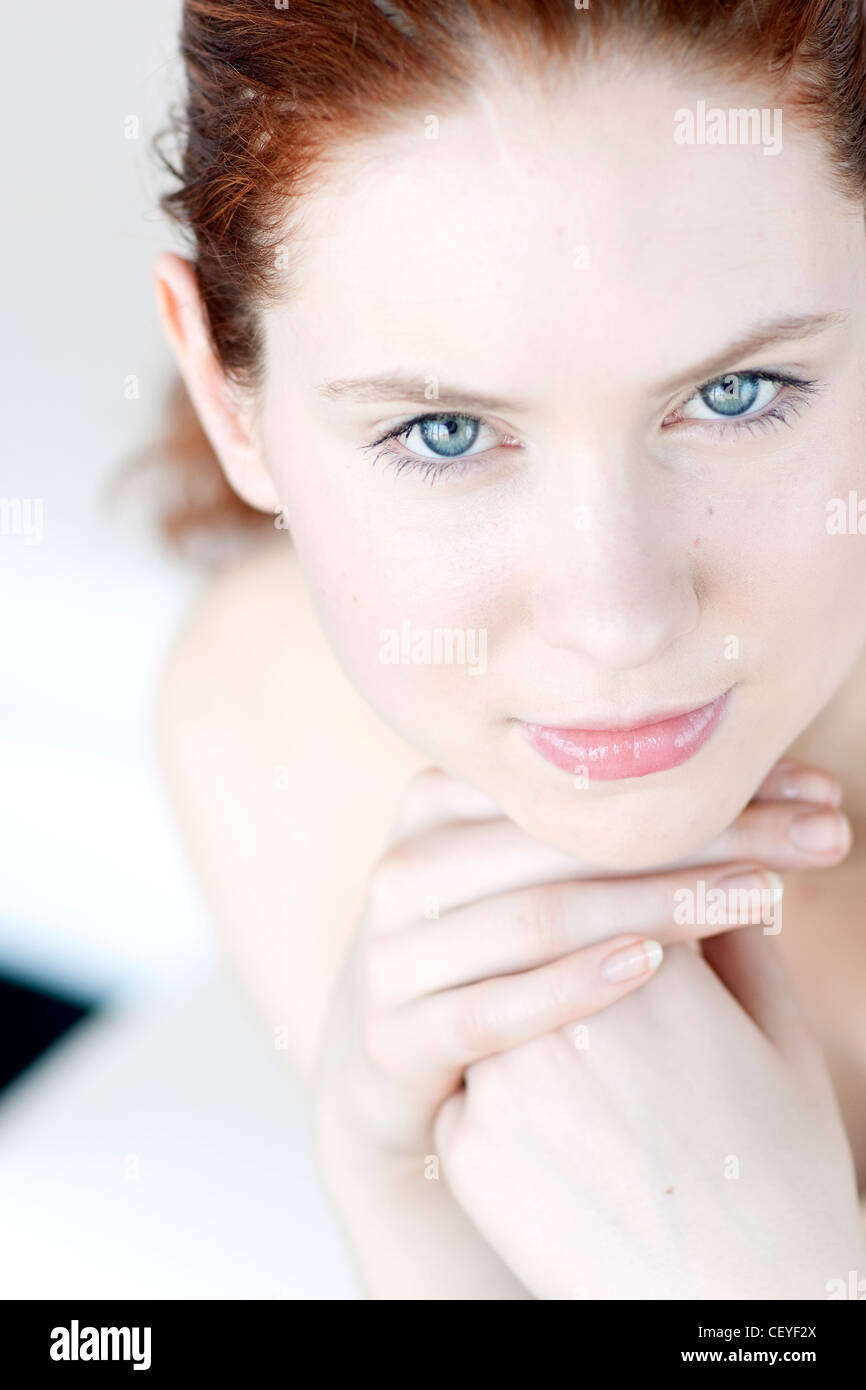 Female with ginger hair off her face, wearing subtle make up, chin on ...