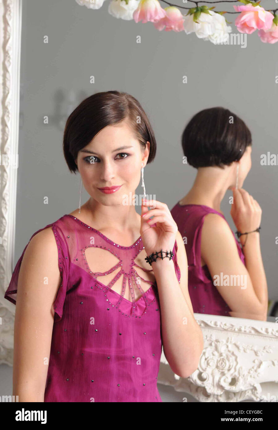 Female short brunette hair, wearing a mauve top cut out chest detail ...