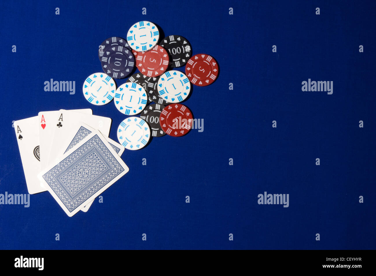 Poker hand layed out on blue background with two hidden cards and chips ...