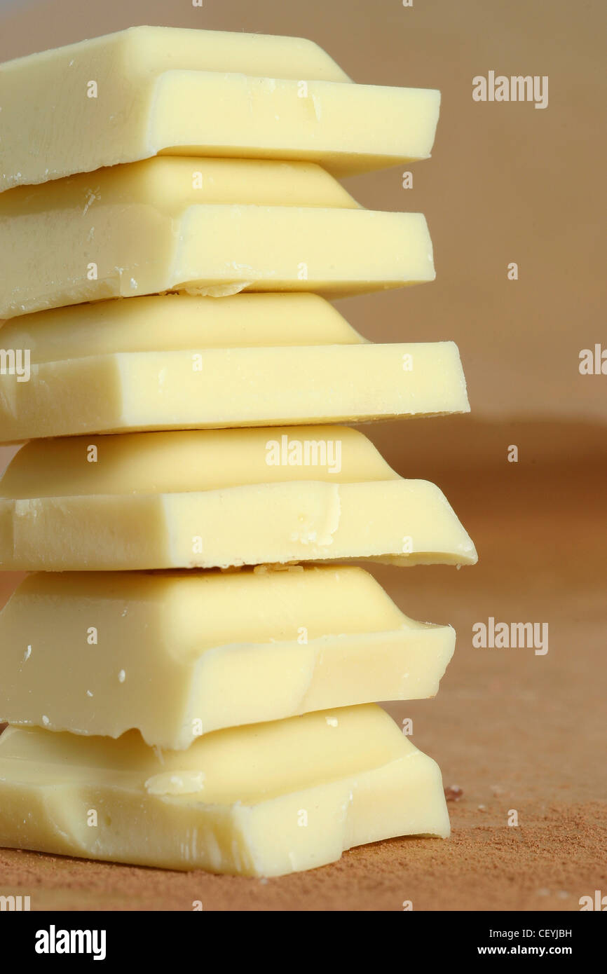 A stack of squares of white chocolate on a wooden board Stock Photo - Alamy
