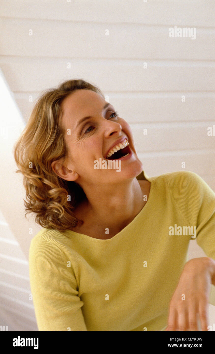 Female with short fair hair, wearing a yellow jumper, smiling, looking ...