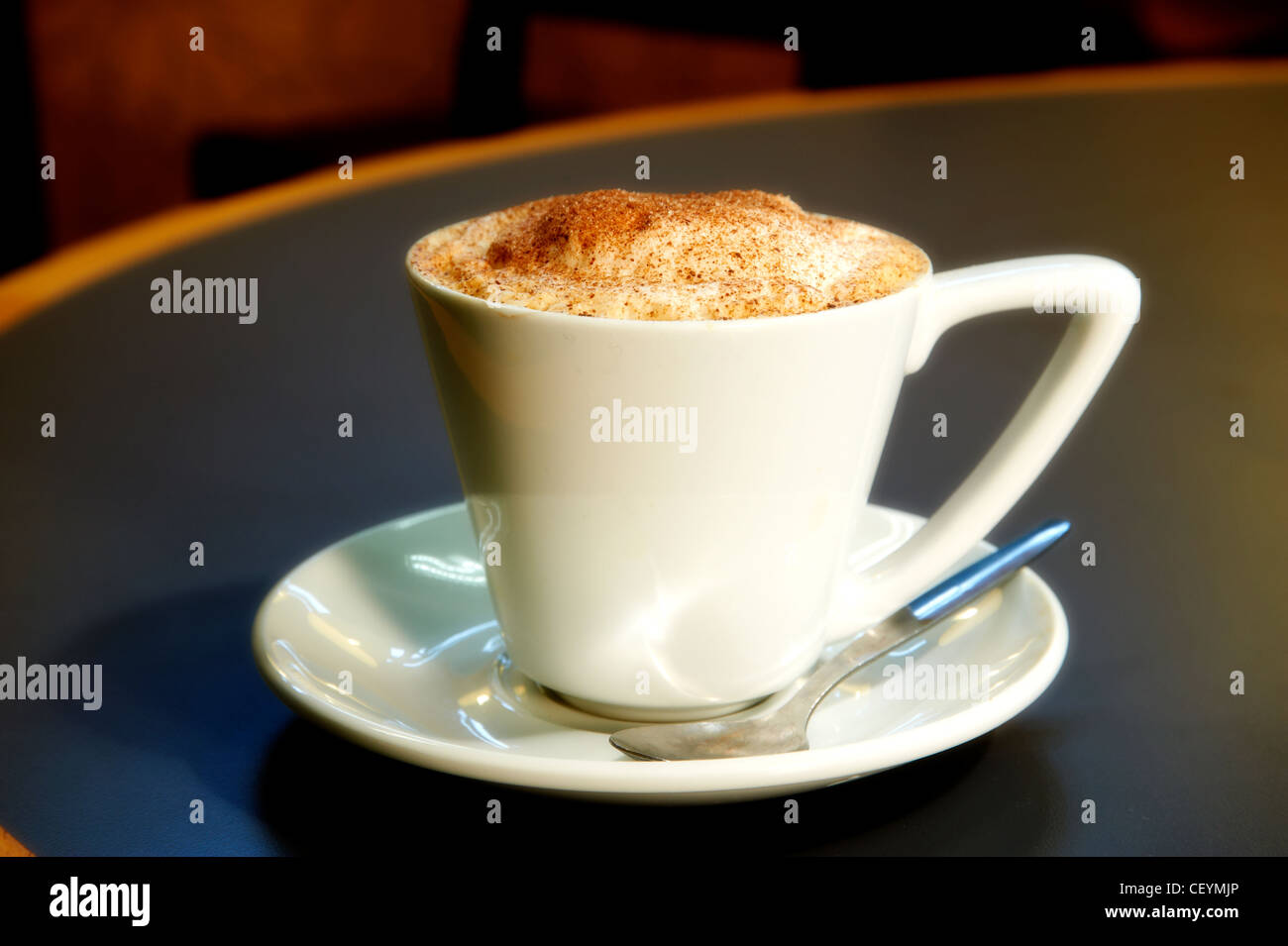 A chocolate sprinkled small cappuccino coffee in a white cup on a ...
