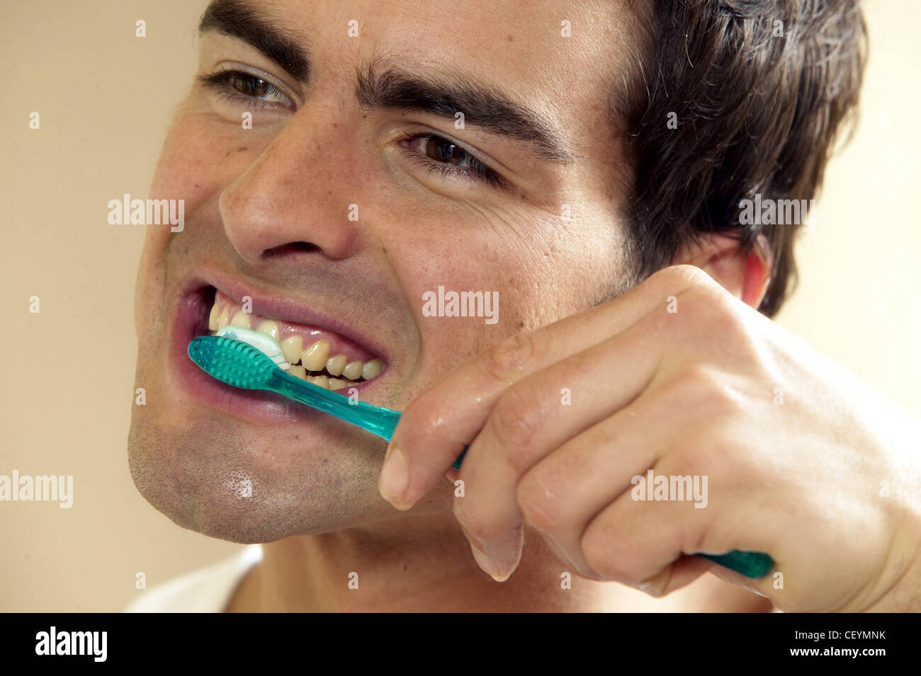 Male dark brown hair wearing white vest top, brushing teeth green ...