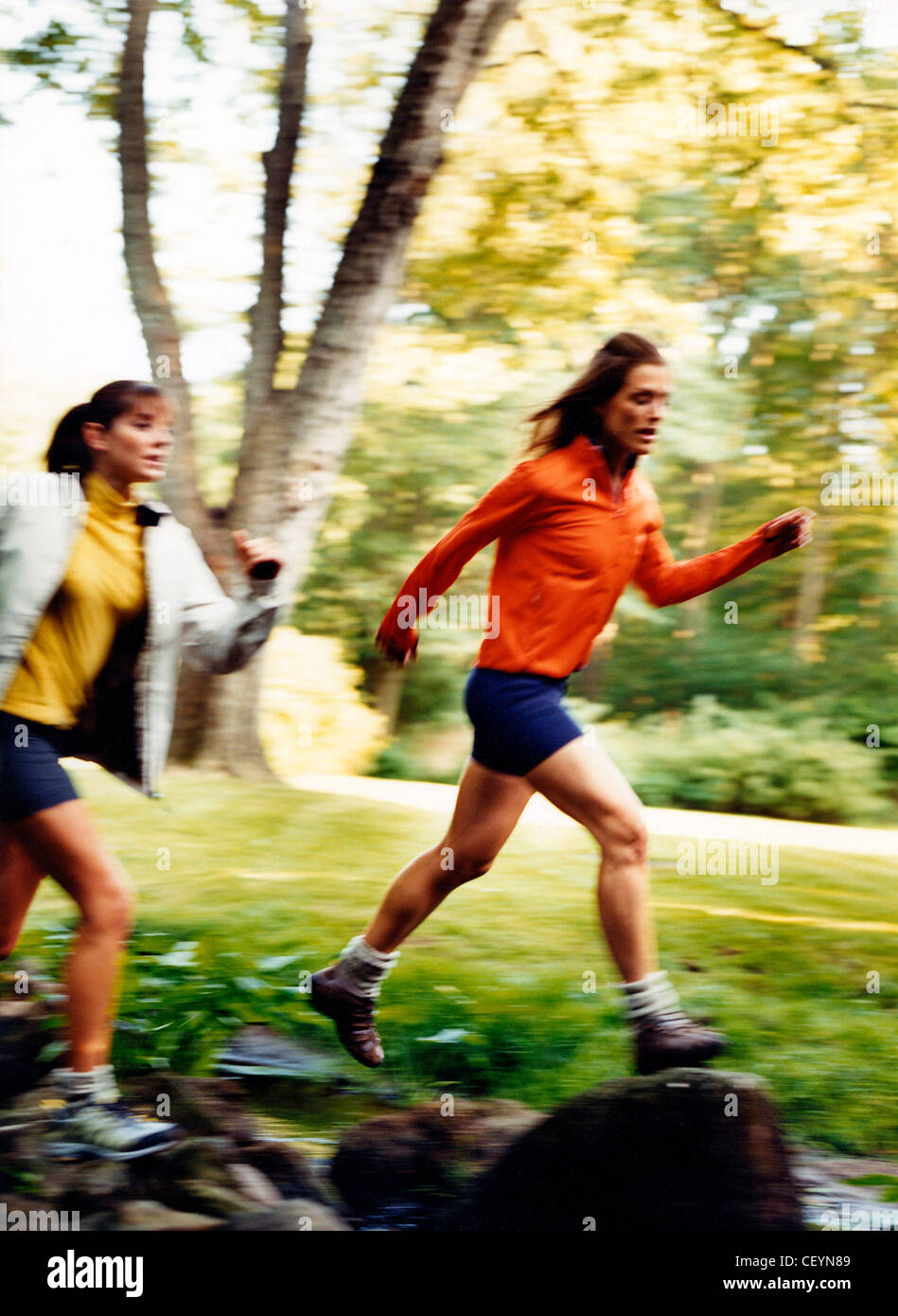 Two female runners, female on left brunette hair in ponytail wearing ...