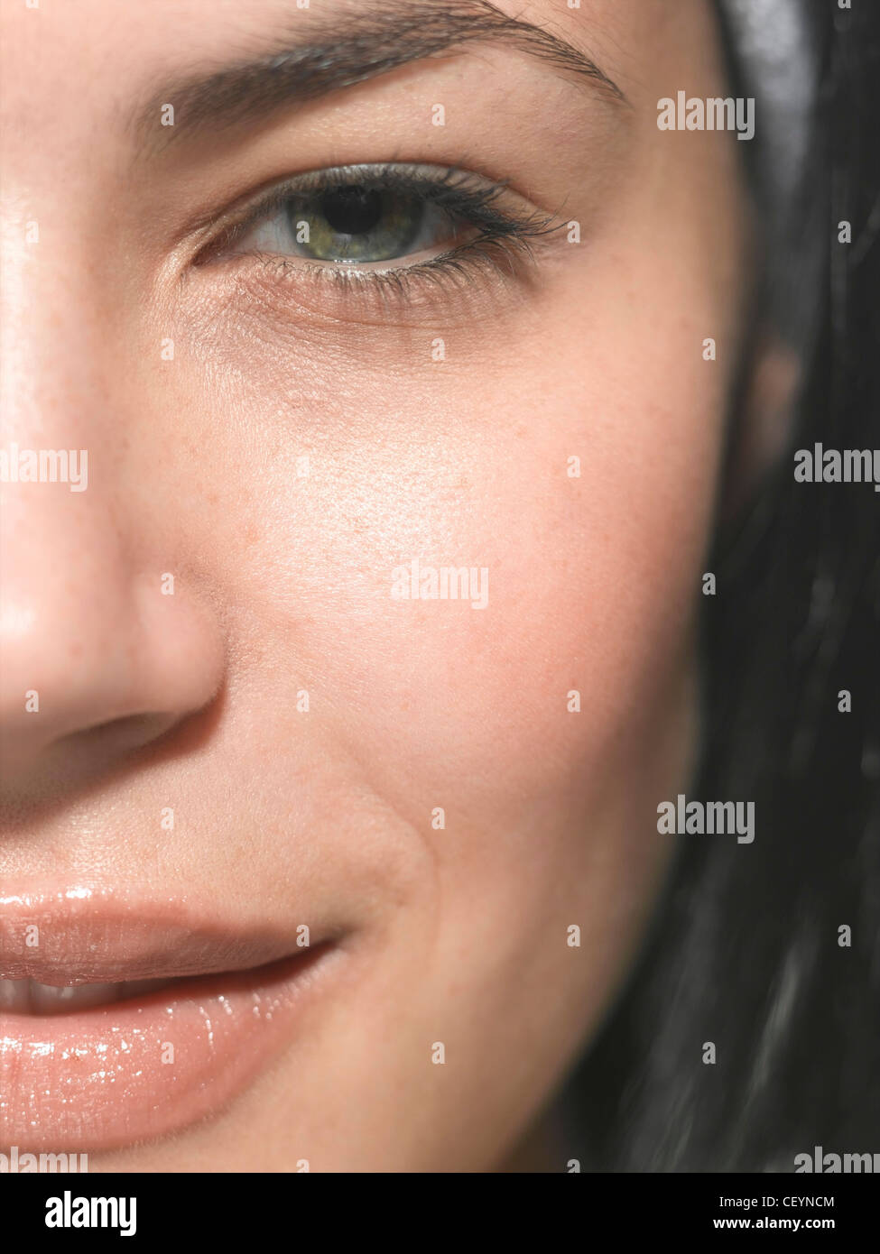 Cropped face of female with dark brunette hair held off face with white ...