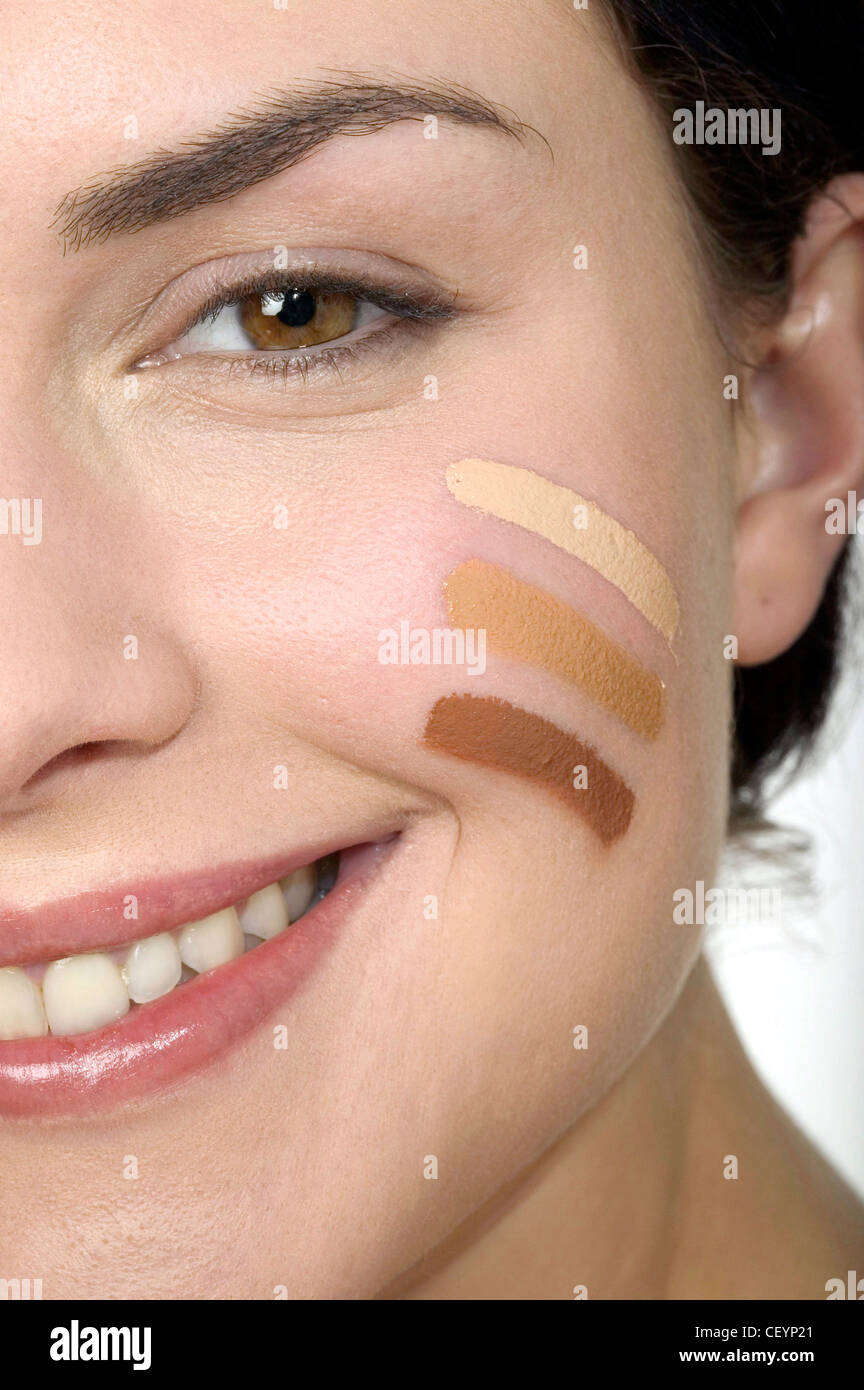 Half face of female three stripes of different shades of foundation on ...