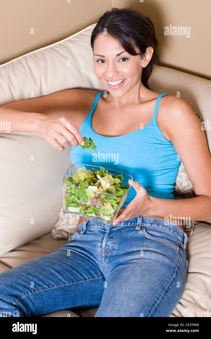Brunette female hair tied back wearing a blue vest and blue jeans ...