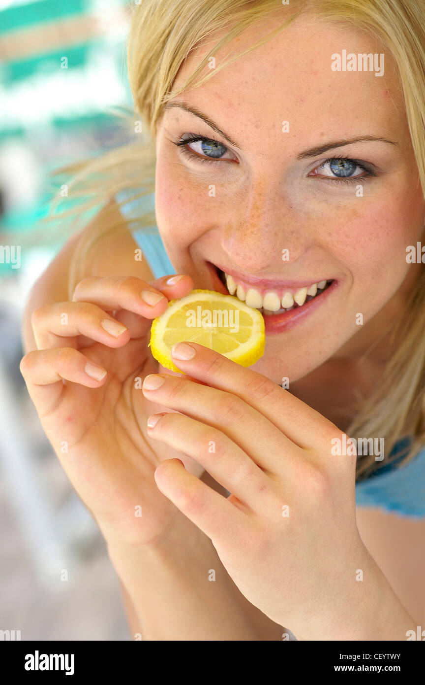 Female biting a slice of lemon Stock Photo - Alamy