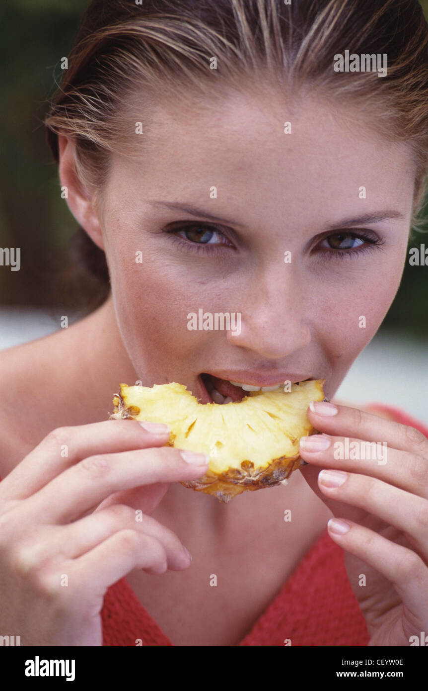 Female eating pineapple Stock Photo - Alamy