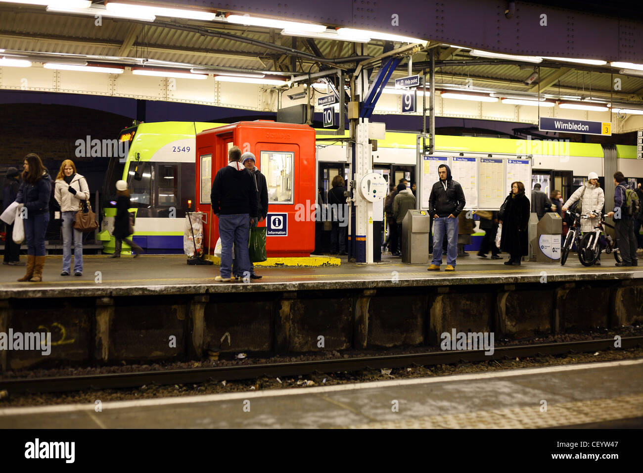 Passengers waiting for a train on a platform at Wimbledon train station ...