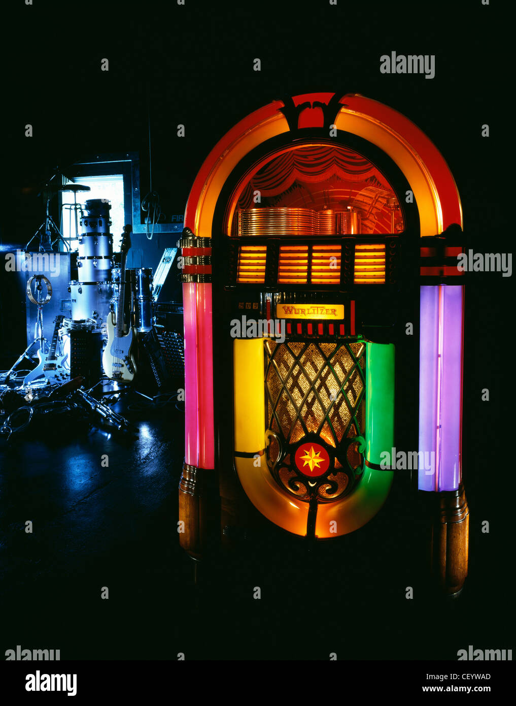 Still life with a jukebox in the foreground and a stack of musical ...