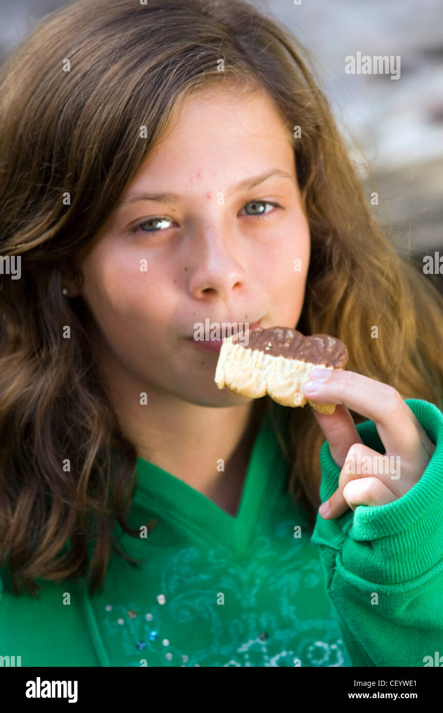 Female eating a chocolate covered biscuit Stock Photo - Alamy