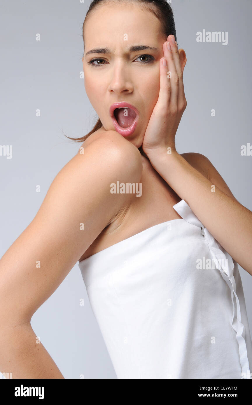 Female wearing a white strapless dress gasping with hand to side of ...