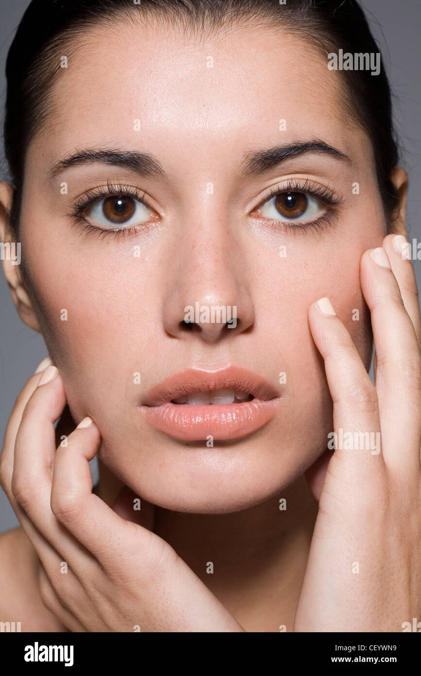 Female wearing natural minimal style make up touching her face with her ...