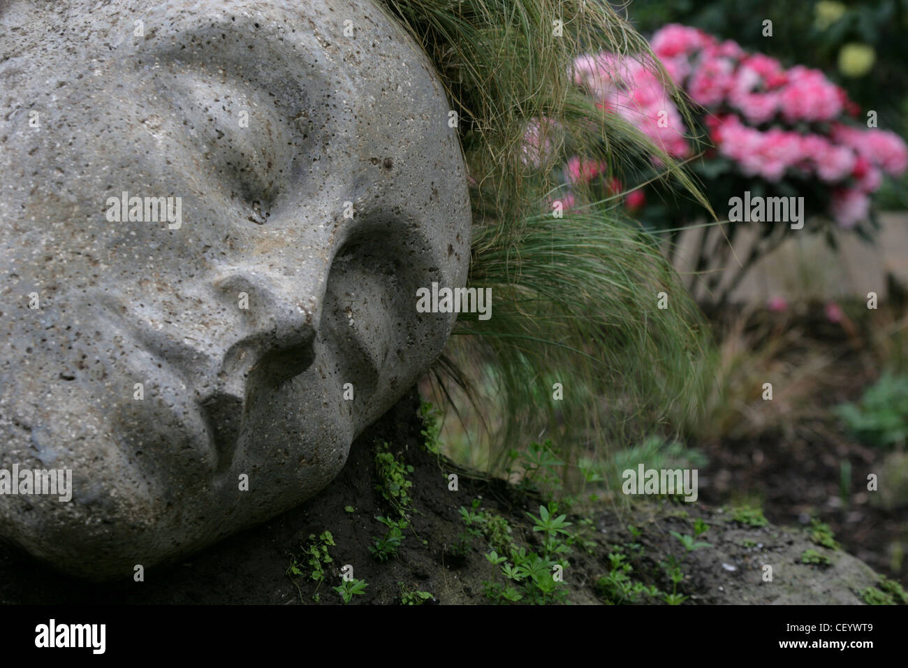 Sculpture of a sleeping woman with her head made out of grey stone with ...