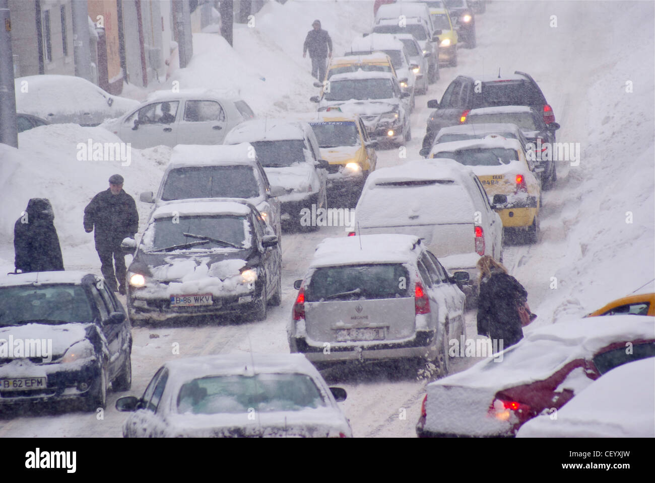 Cars and pedestrians struggle on the roads in blizzard conditions Stock ...