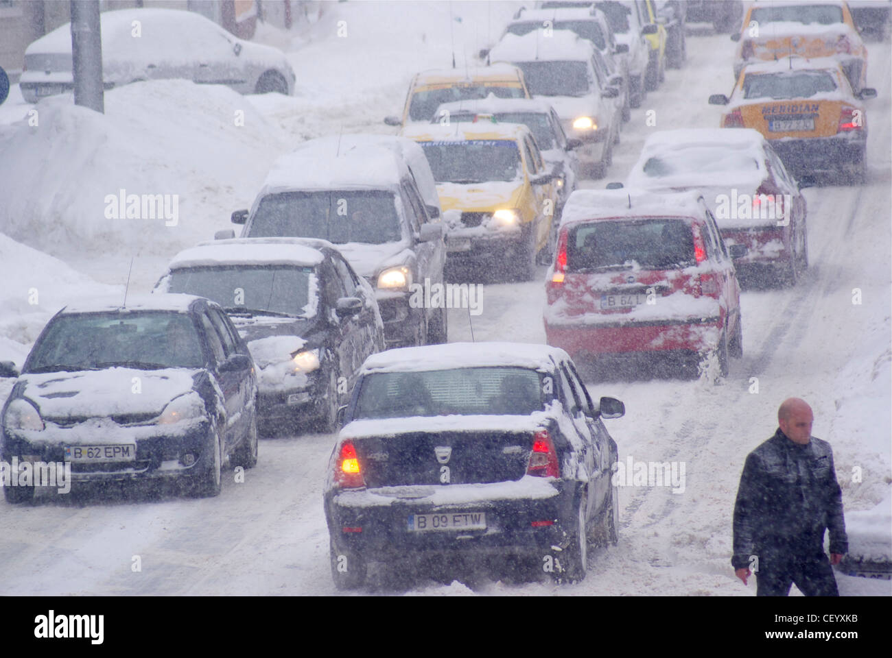 Cars and pedestrians struggle on the roads in blizzard conditions Stock ...
