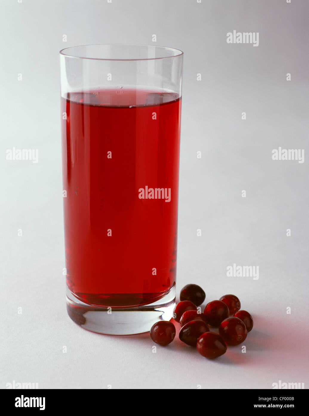 A glass of cranberry juice with fresh cranberries next to it Stock ...
