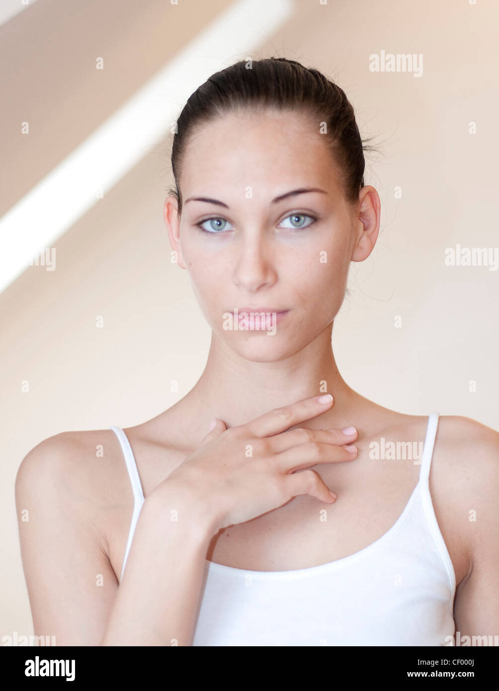 Female With Brunette Hair Off Her Face Wearing A White Camisole