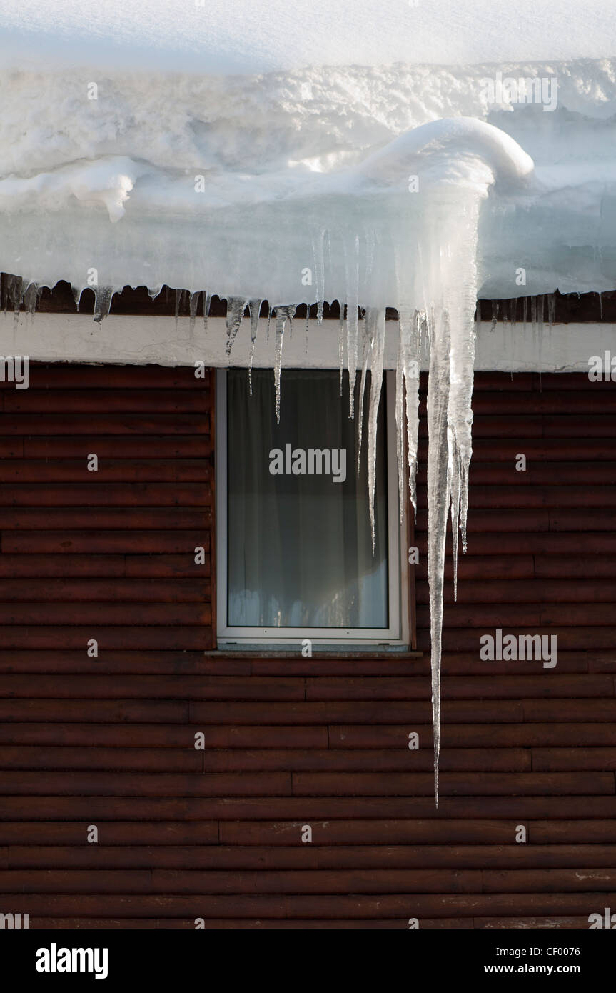 Icicles on window. Wooden house windows Stock Photo - Alamy