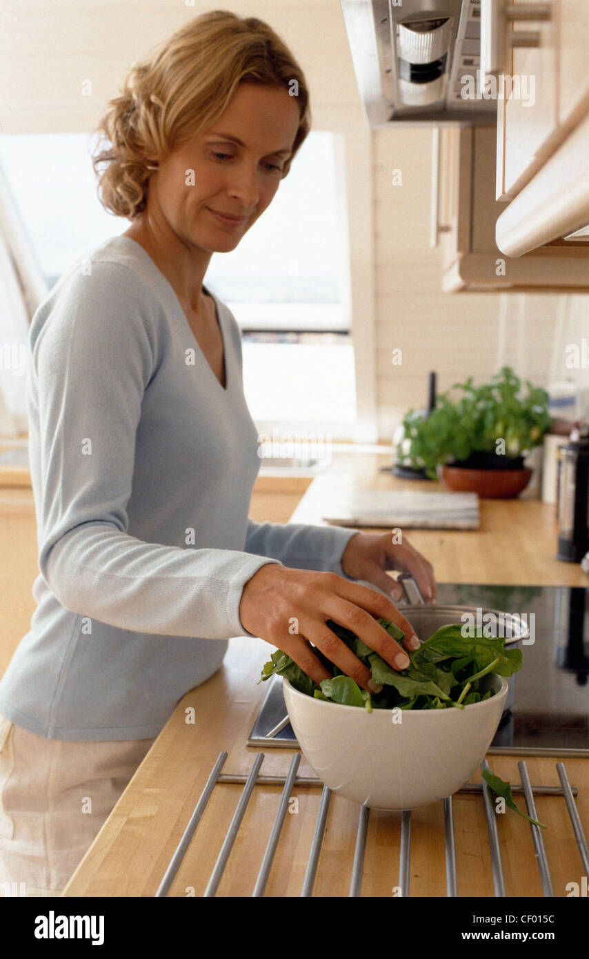 Female short fair hair, wearing a blue v neck top and white trousers ...