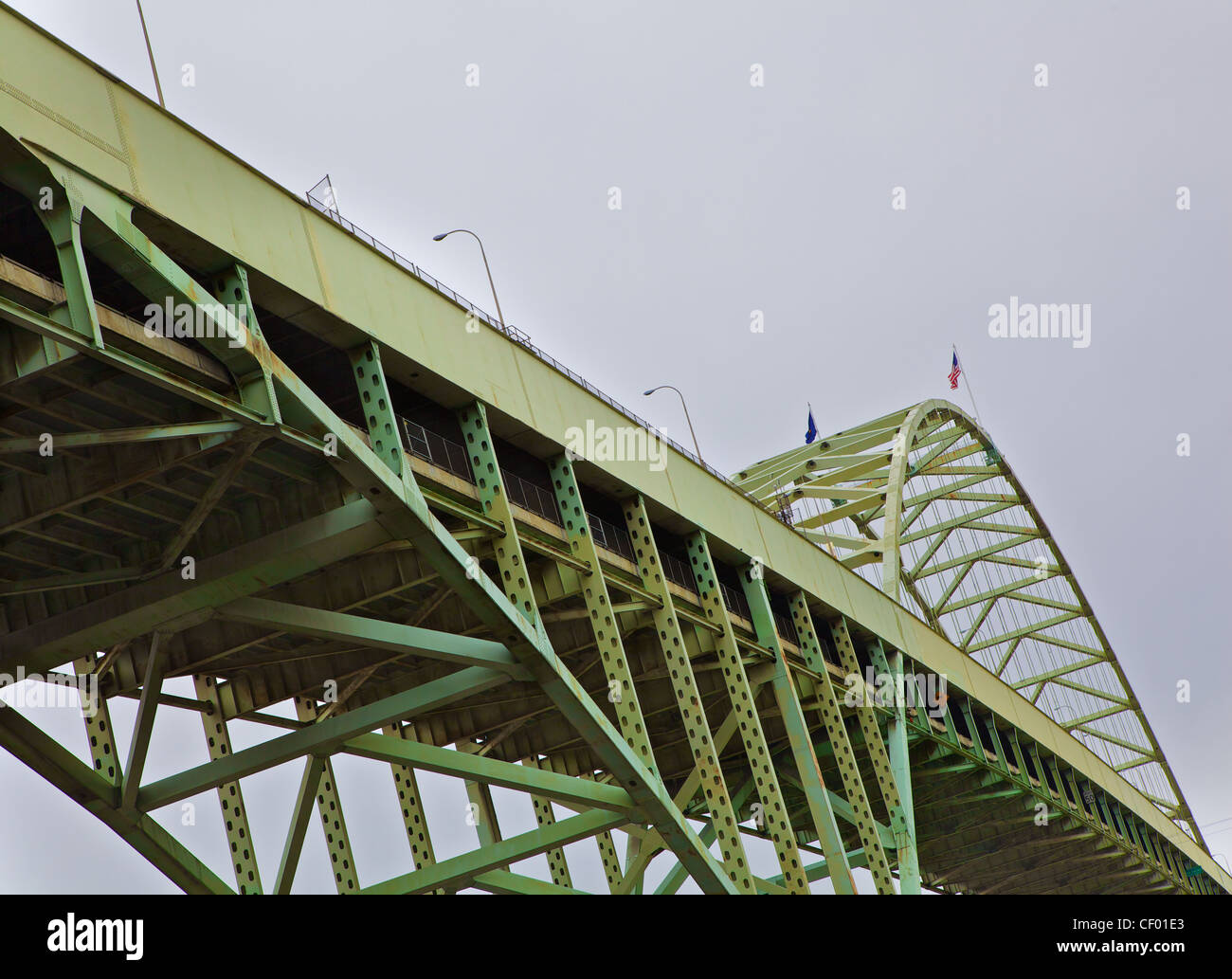Old Steel bridge from bottom looking up towards gray and cloudy sky ...