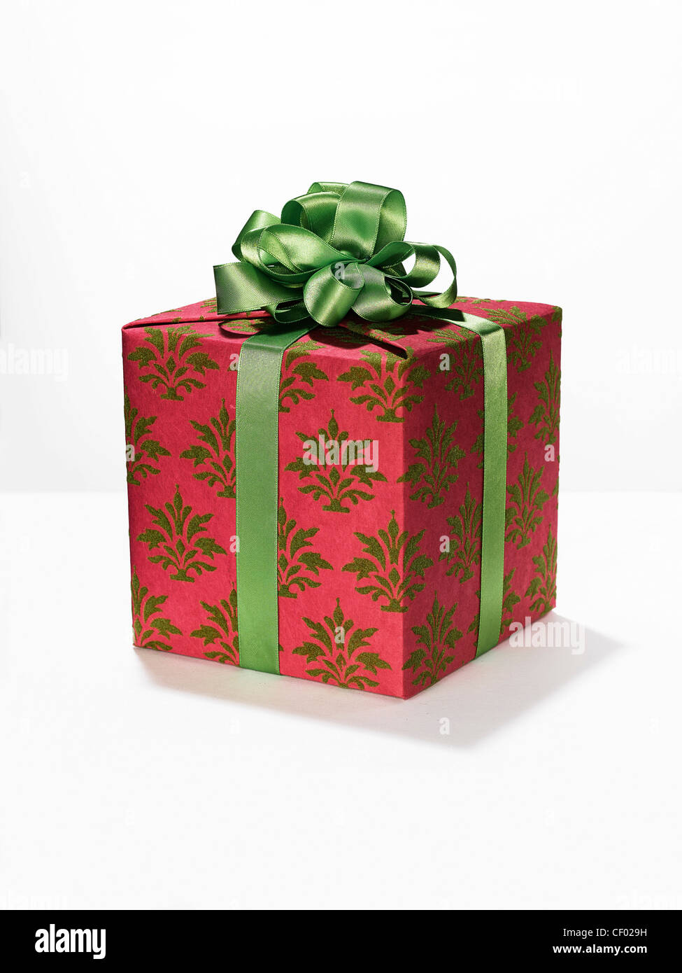 A square present wrapped in red and green wrapping paper with a green ...