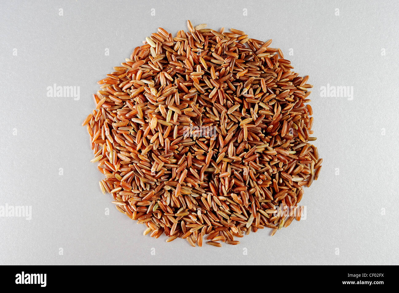 A small round pile of red rice Stock Photo - Alamy