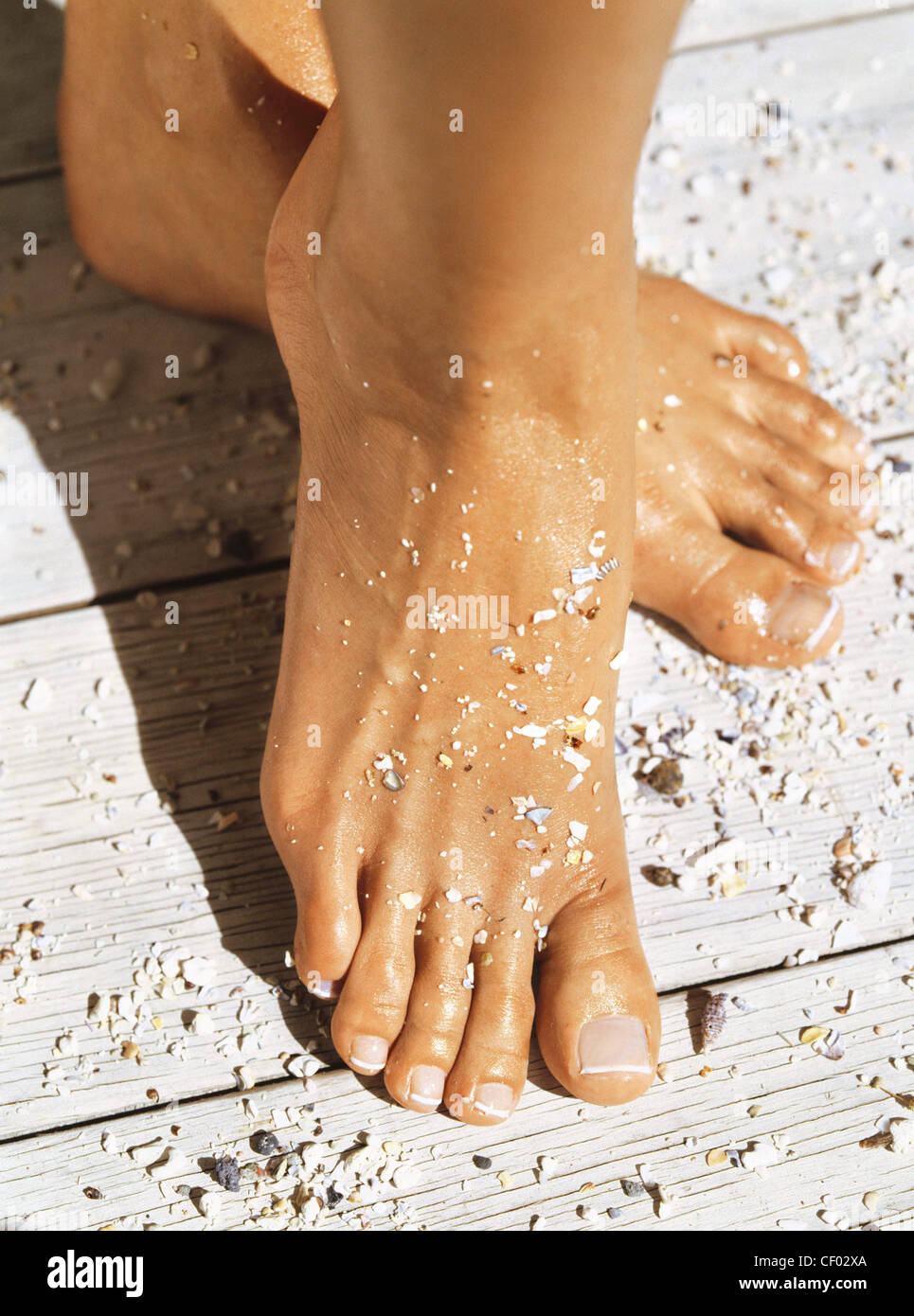 Beauty at Home Cropped image of female feet standing on wooden flooring ...