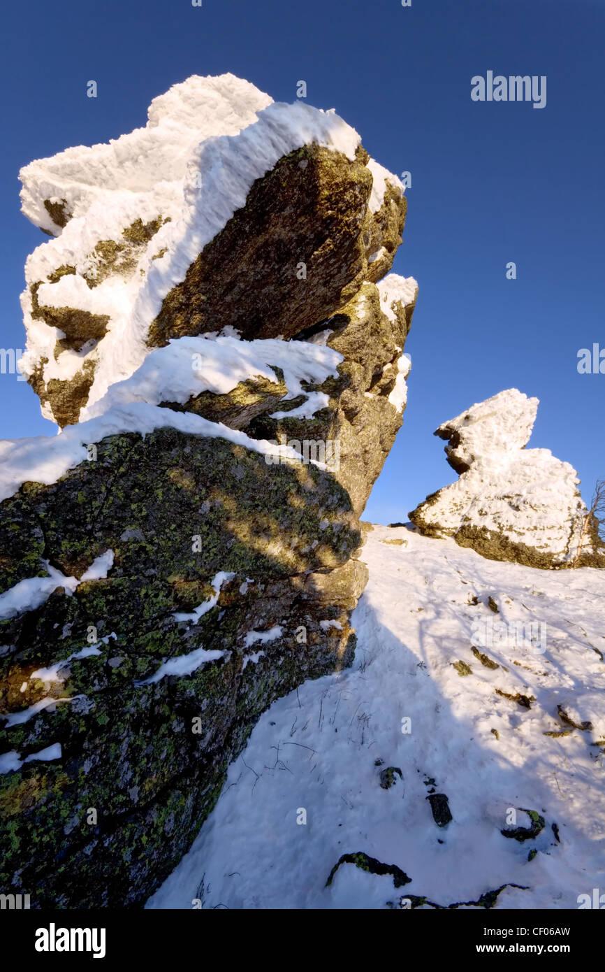 Snow-covered rocks against blue sky. Siberia. Taiga. National park ...