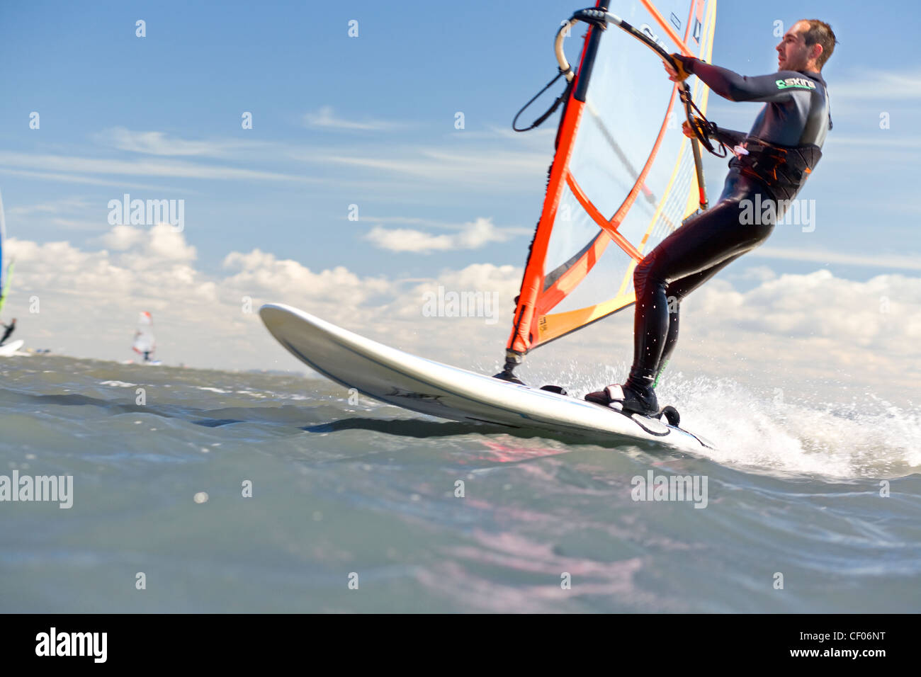 a windsurfer upright on his board surfs across the sea Stock Photo - Alamy