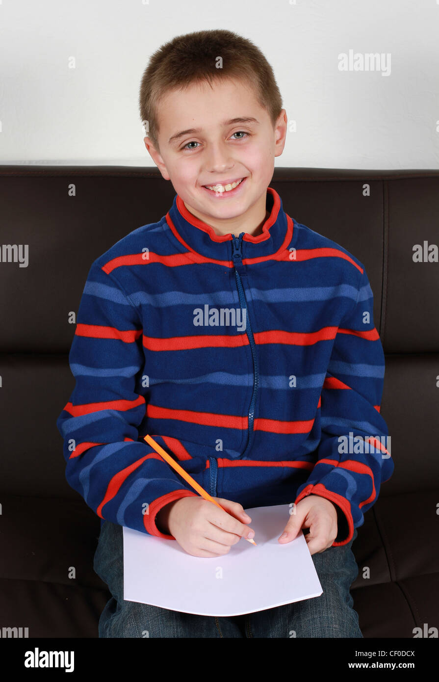 Young boy writes on some blank plan white paper Stock Photo - Alamy