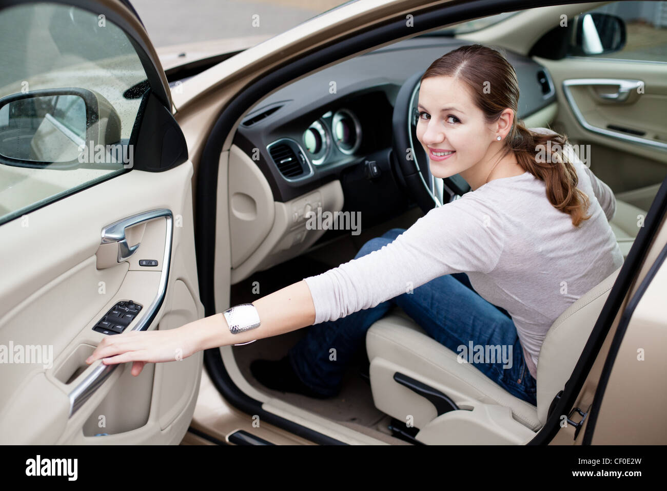 Pretty young woman driving her new car Stock Photo - Alamy