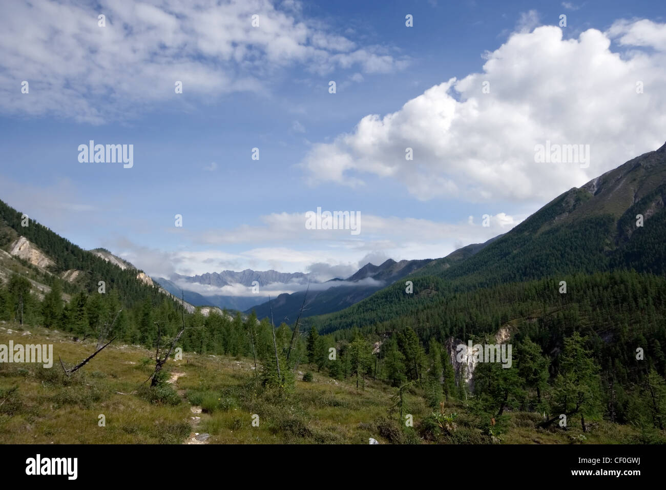 Valley in Sayan mountains against a blue sky with clouds. East Sayan ...