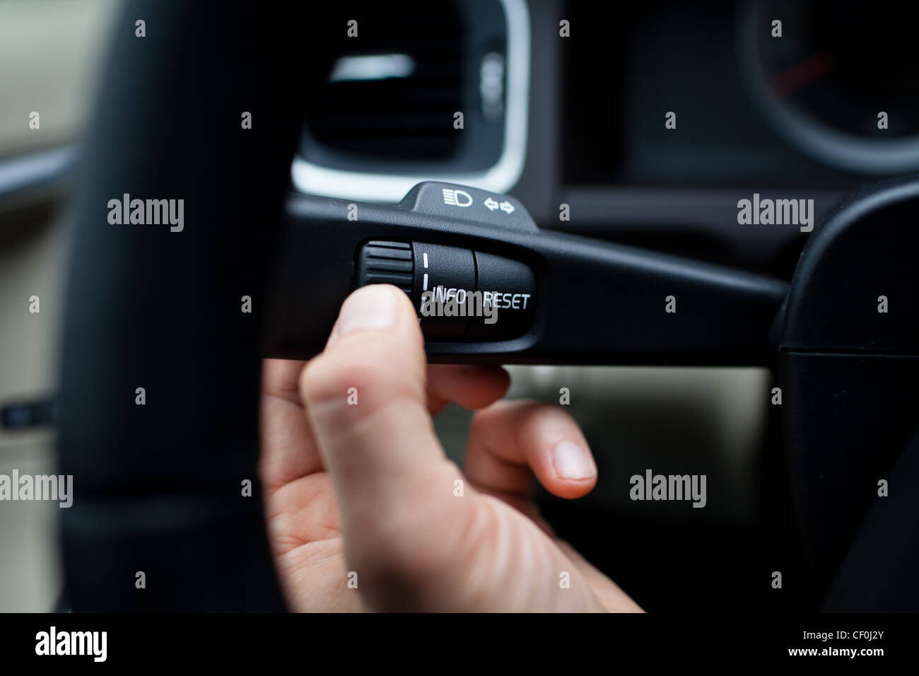 Modern car interior - driver pressing a button, using the car computer ...