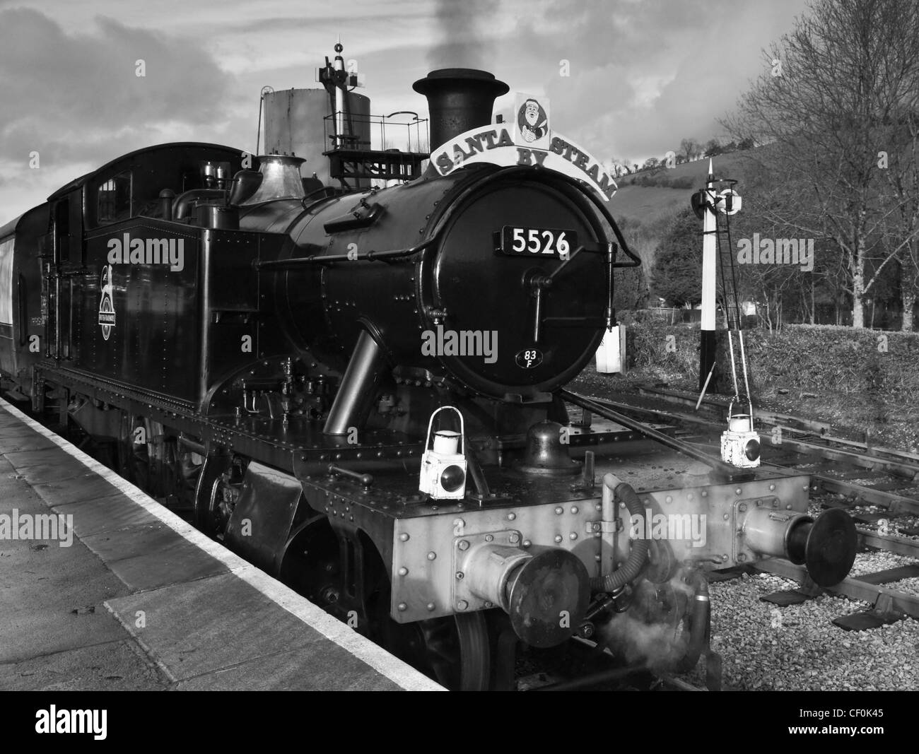 A black and white landscape shot of a steam engine three quarter side ...