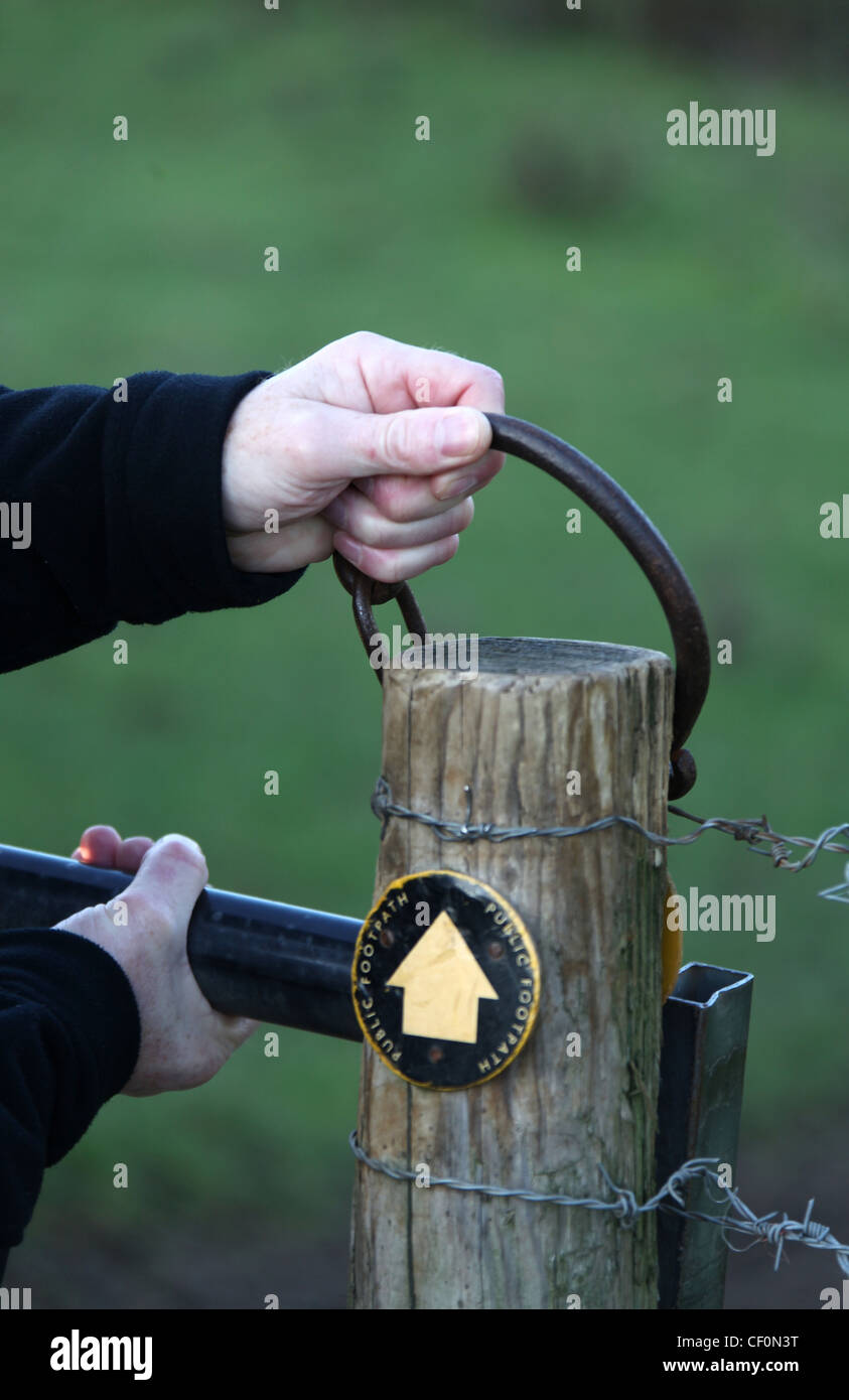 Man opening a gate in the countryside Stock Photo - Alamy
