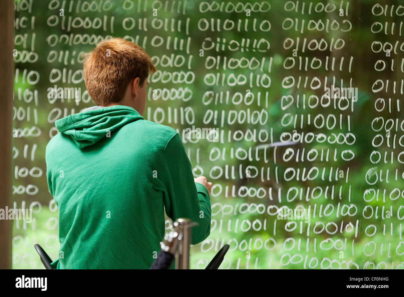 A Young Man Observes A Display Of Binary Code On A Window Representing Artwork Inside The 