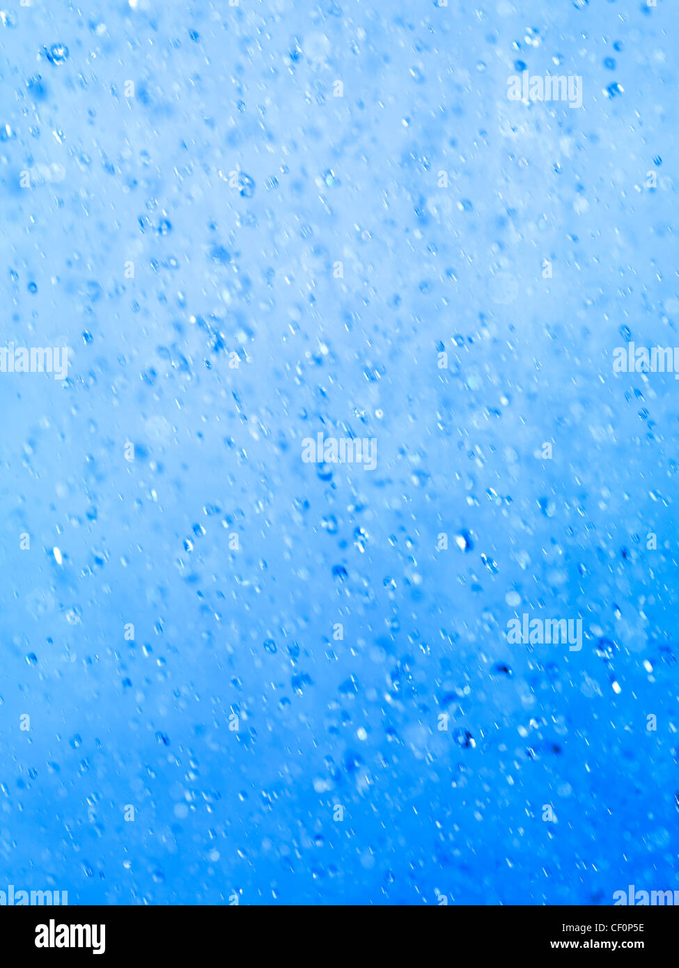 Closeup of blue spraying water droplets abstract blue background ...