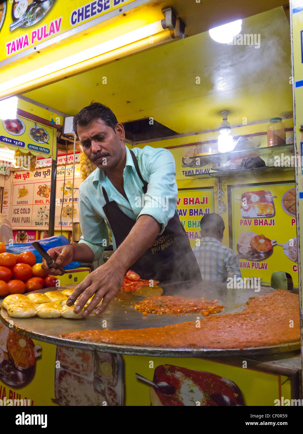 a chef cooking in a small carry-out shop in Juhu Beach, Mumbai ...