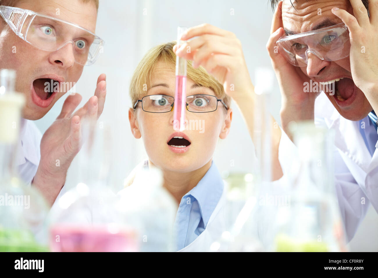 Three shocked scientists looking at the obtained substance expressing ...