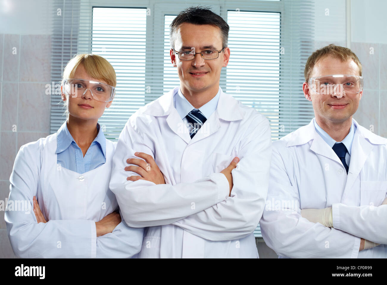 Three positive scientists looking at camera and smiling Stock Photo - Alamy