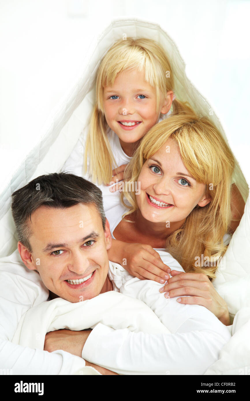 Playful family hiding under blanket isolated on white background Stock ...