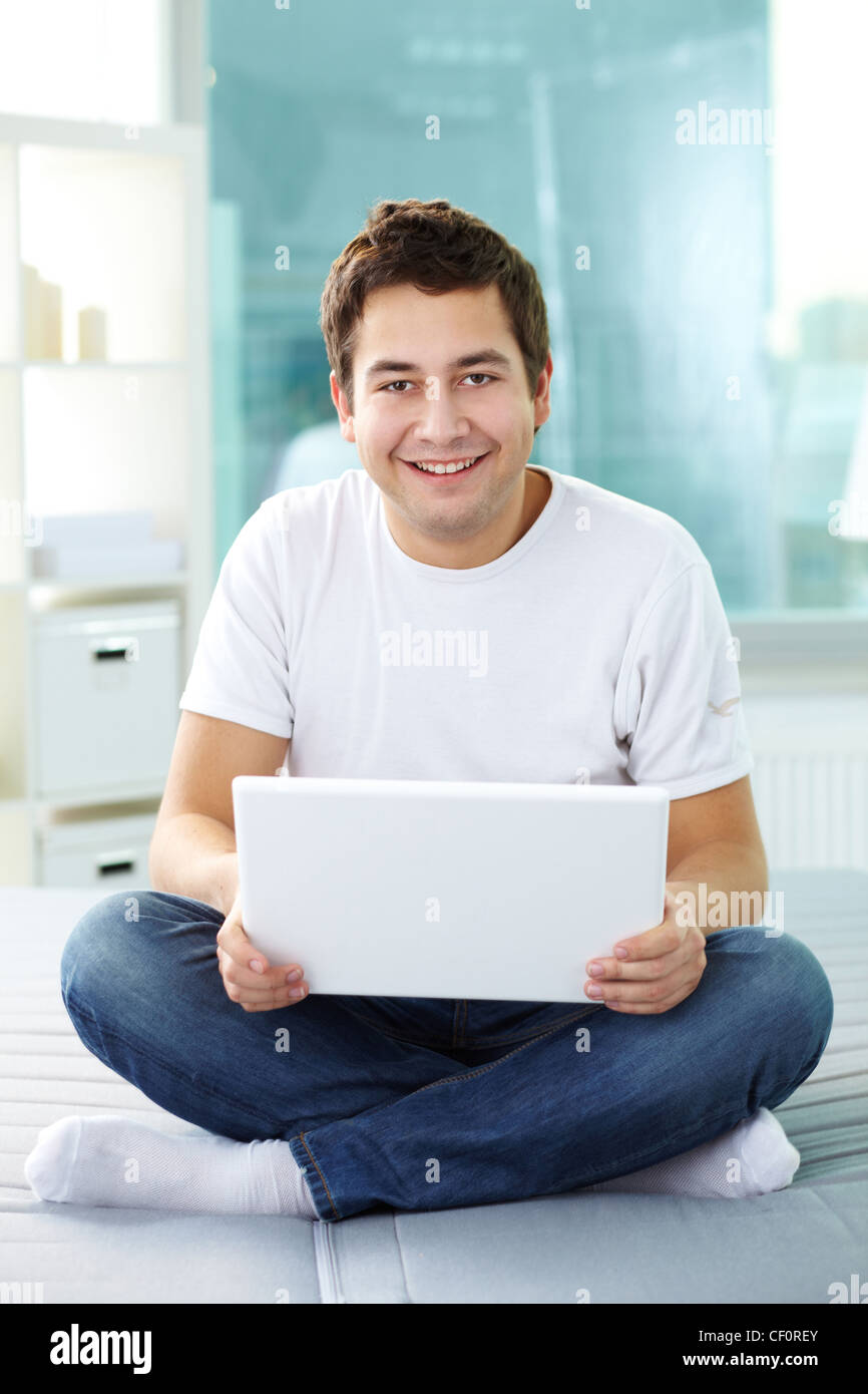 Happy guy with laptop looking at camera and smiling Stock Photo - Alamy