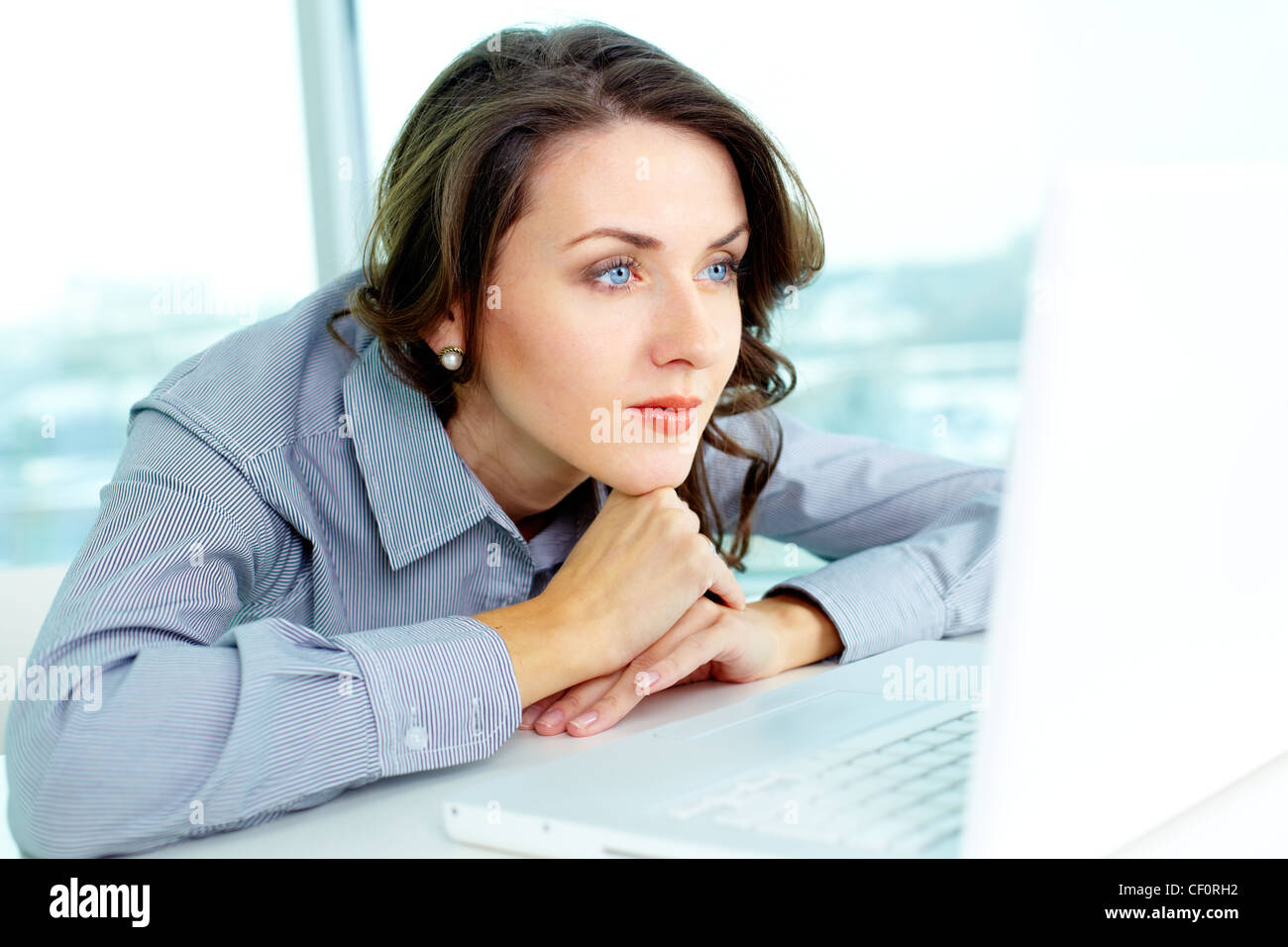 Pensive business woman looking at the screen of computer Stock Photo ...