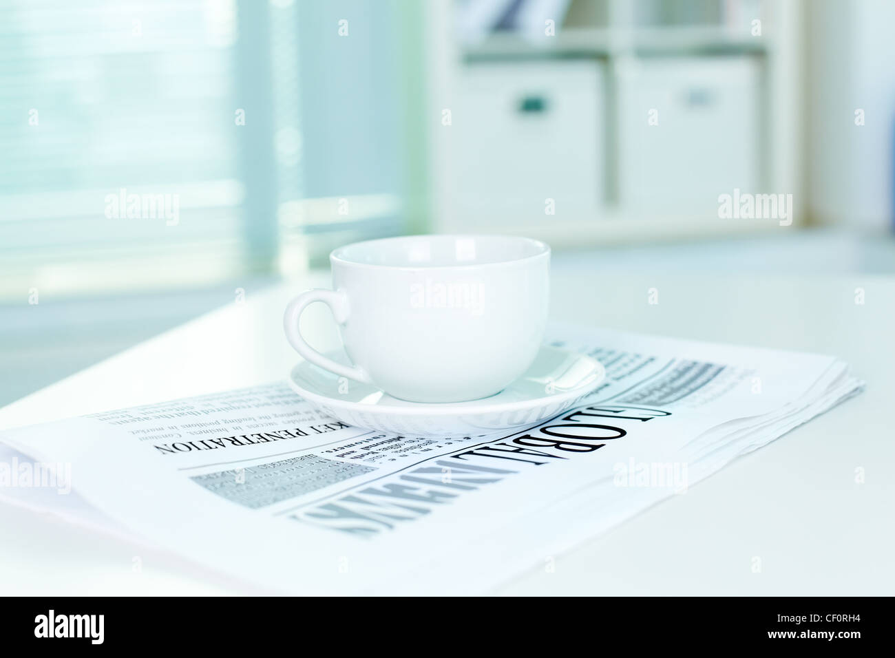 A still of white cup standing on a fresh newspaper in office Stock ...