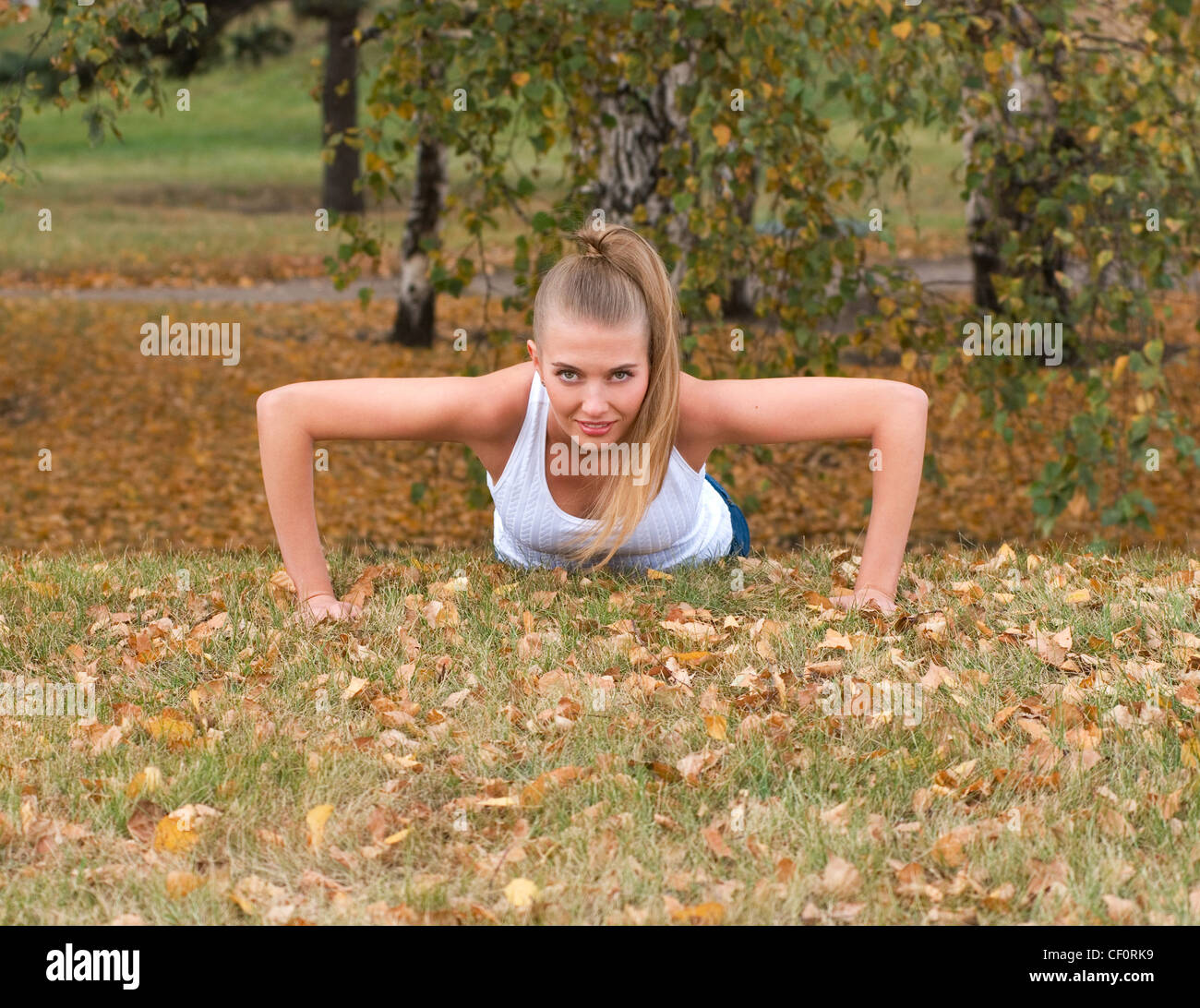 Beauty female doing push ups in the park Stock Photo - Alamy